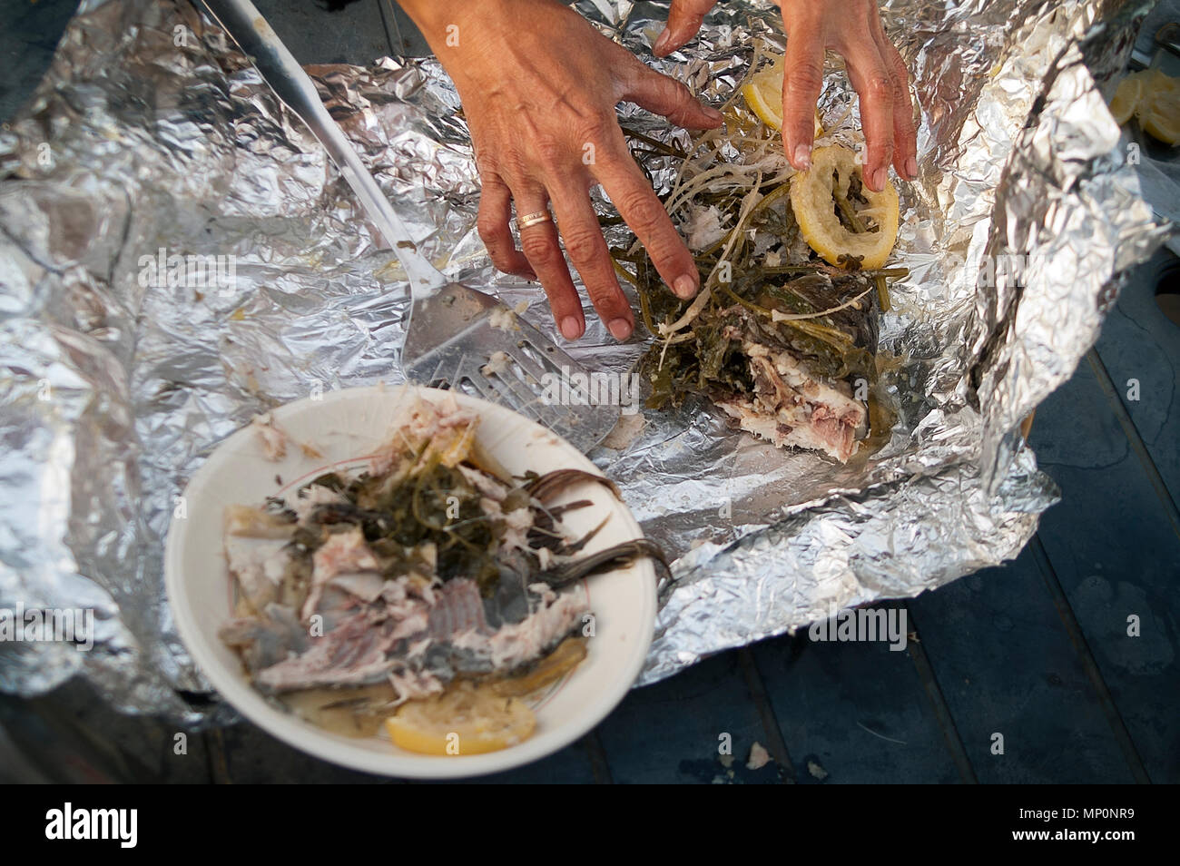 Female hands grabbing food leftovers on a unmade table, above view ...