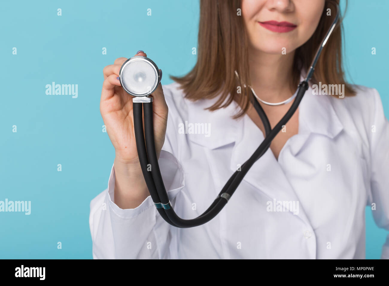 Doctor with stethoscope, close up over blue background Stock Photo - Alamy