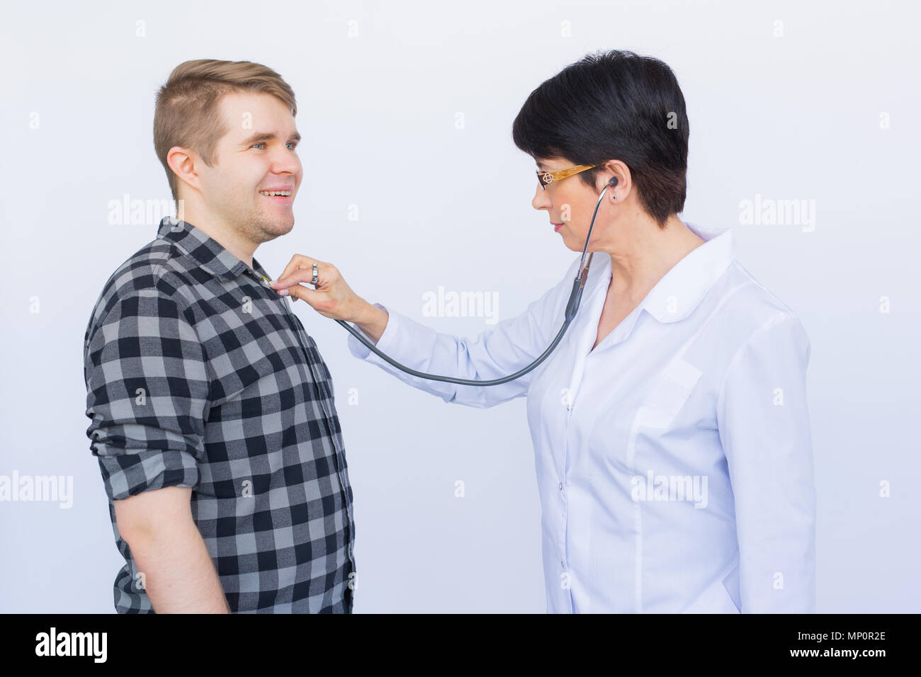 Portrait of confident doctor checking heartbeat of patient Stock Photo ...