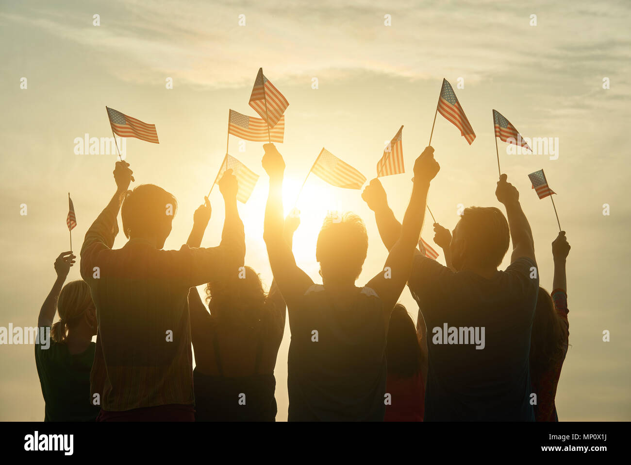 Back view people raising USA flags Stock Photo - Alamy
