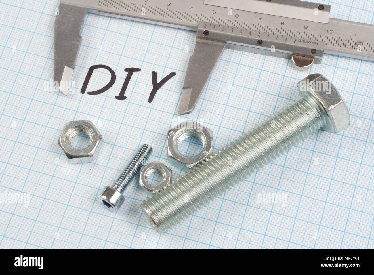 "Do it yourself" - Screw, Nuts and caliper on graph paper background ...