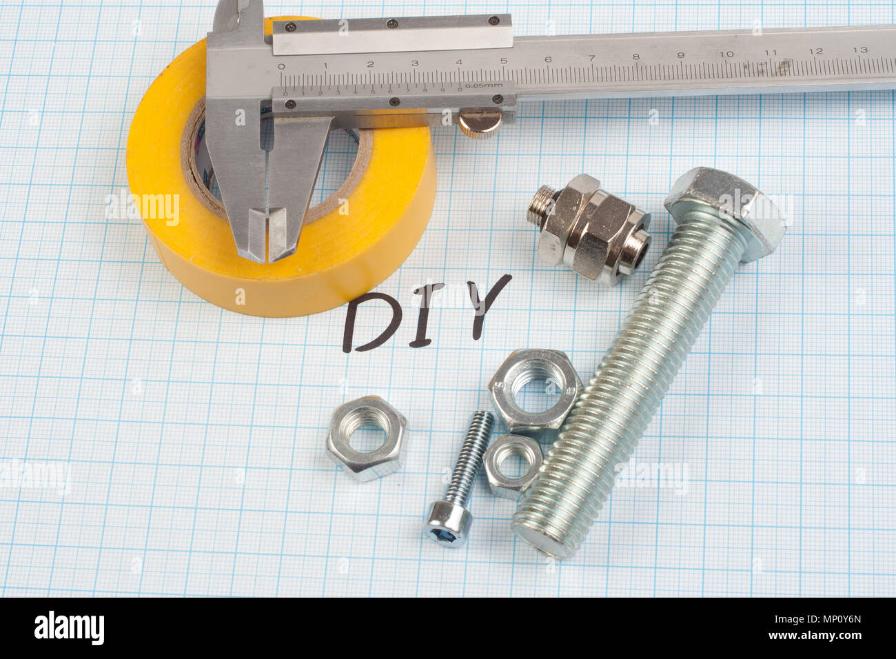 "Do it yourself" - Screw, Nuts and caliper on graph paper background ...