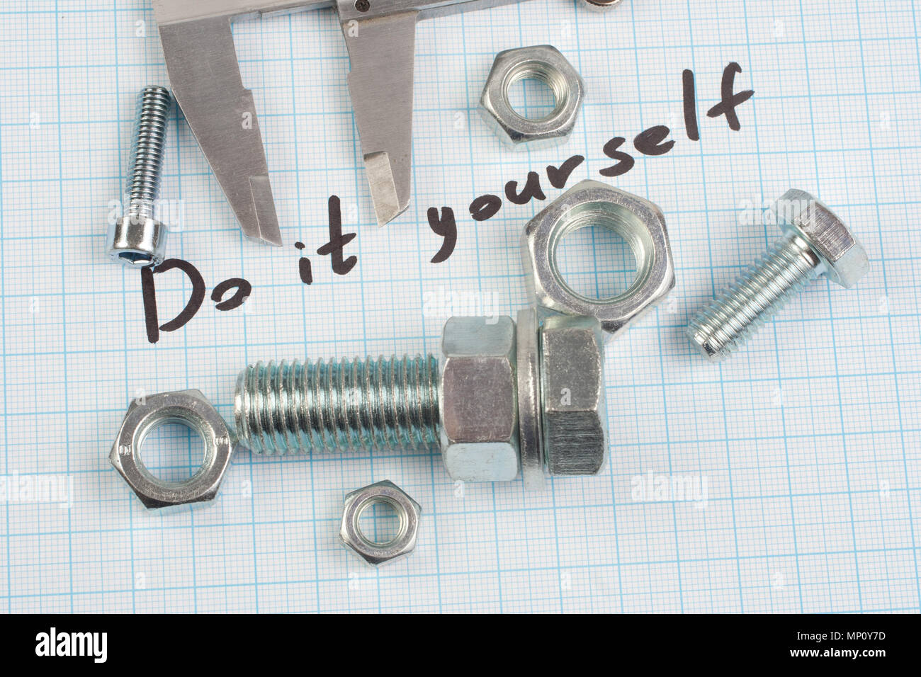 "Do it yourself" - Screw, Nuts and caliper on graph paper background ...