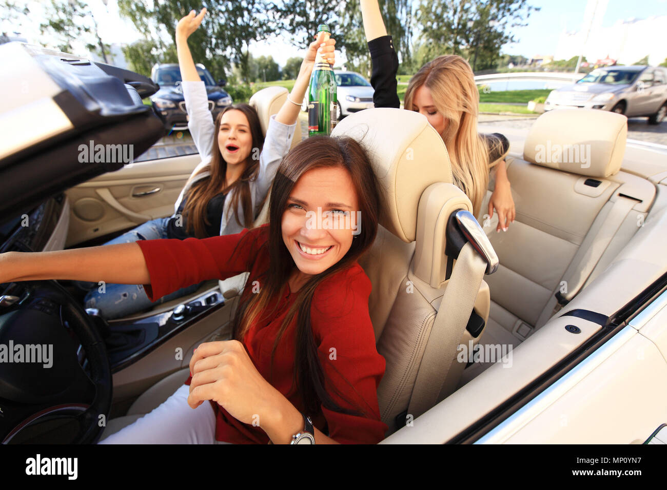 three girls driving in a convertible car and having fun Stock Photo - Alamy