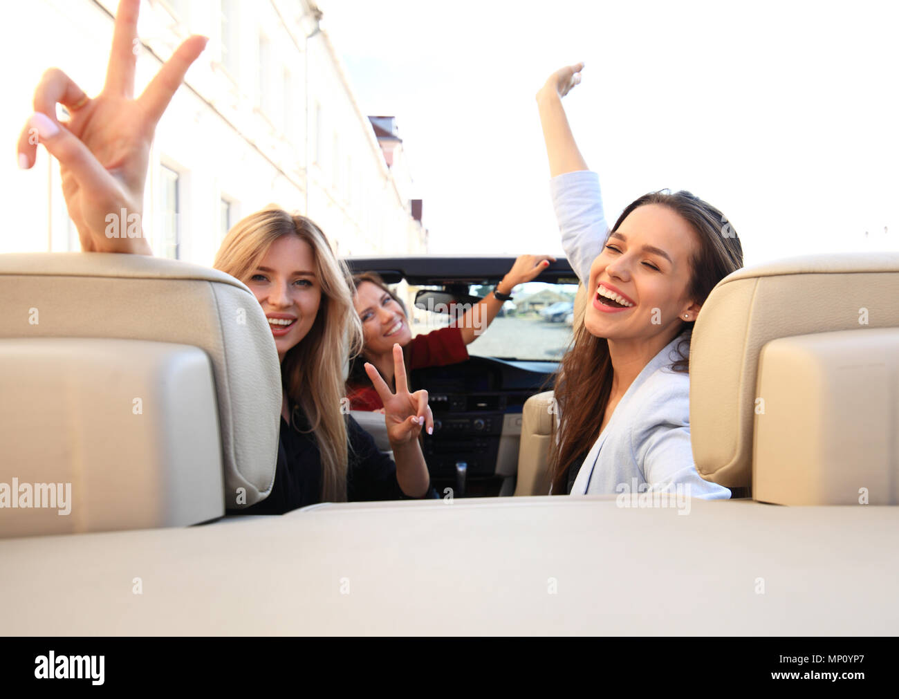 three girls driving in a convertible car and having fun Stock Photo - Alamy