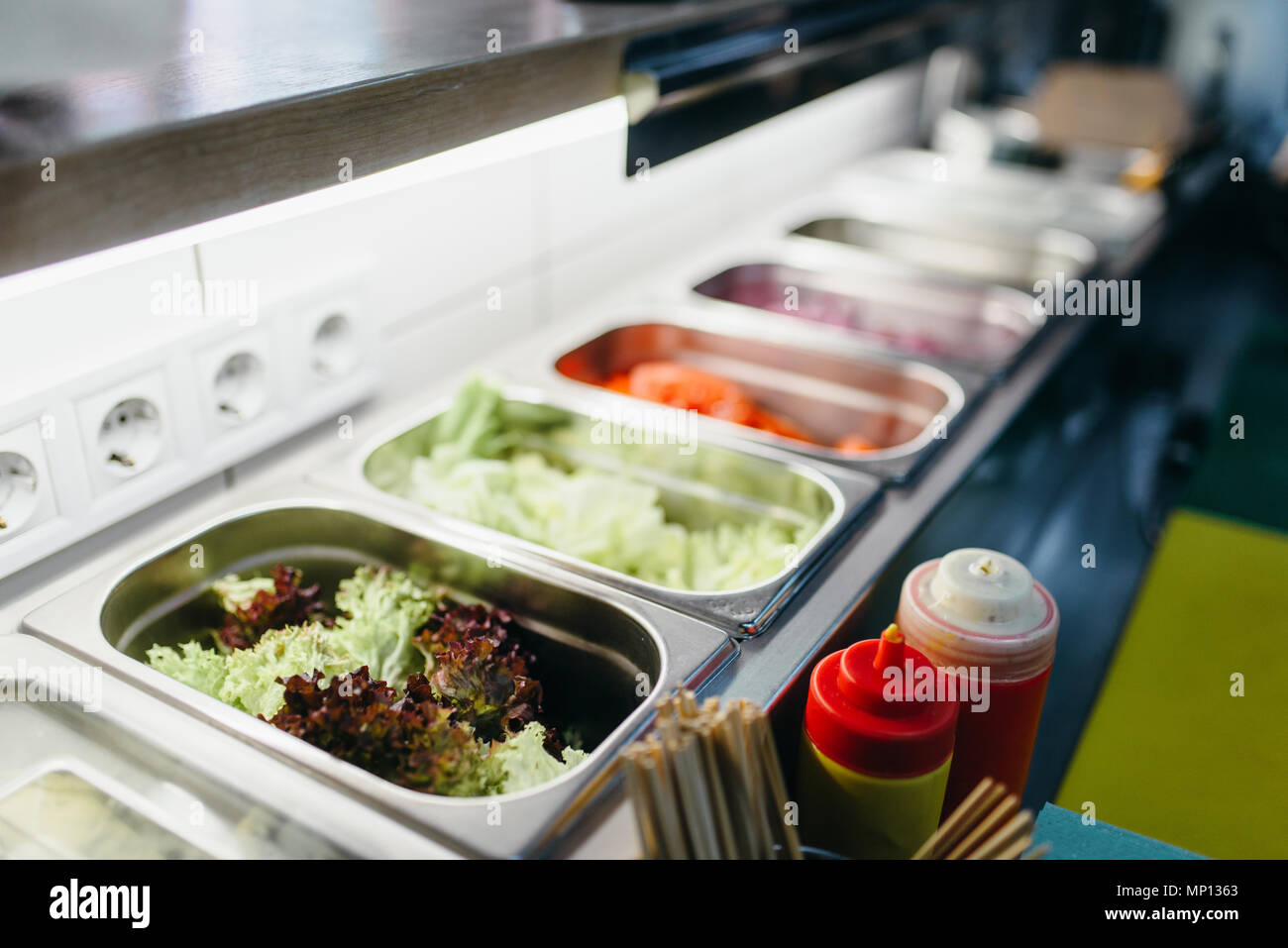 Metal pallets with fresh ingredients for burger cooking, vegetables ...