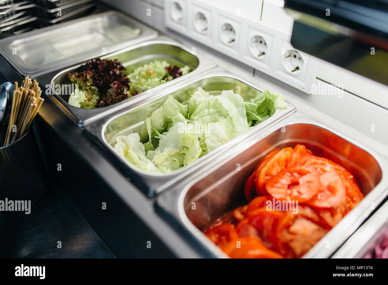 Metal pallets with fresh vegetables for burger cooking, nobody ...