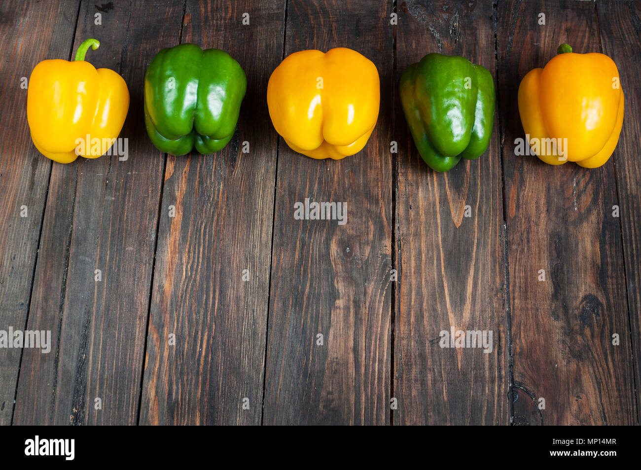 yellow and green paprika on wood background. close up Stock Photo - Alamy