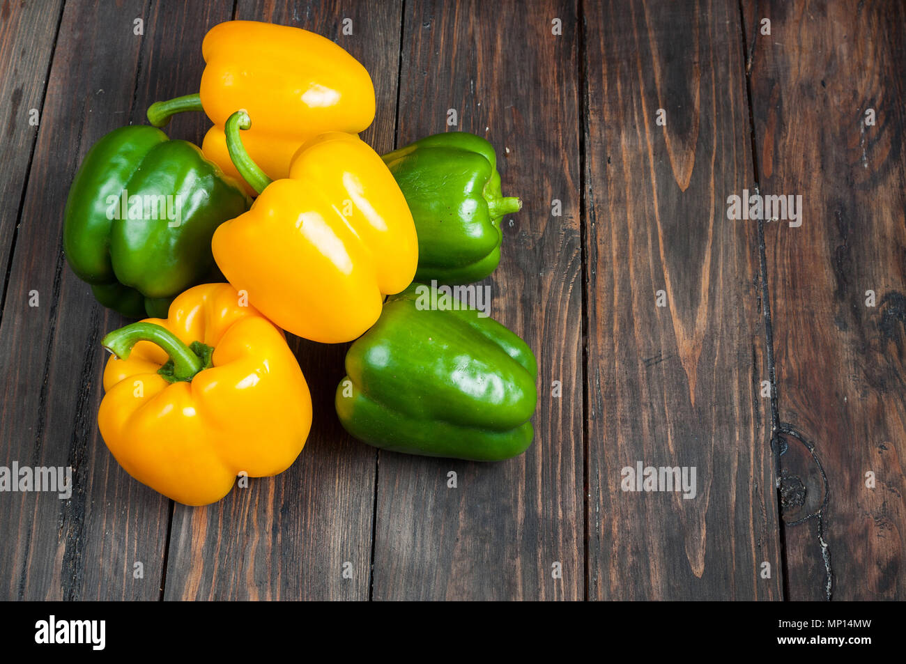 yellow and green paprika on wood background Stock Photo - Alamy