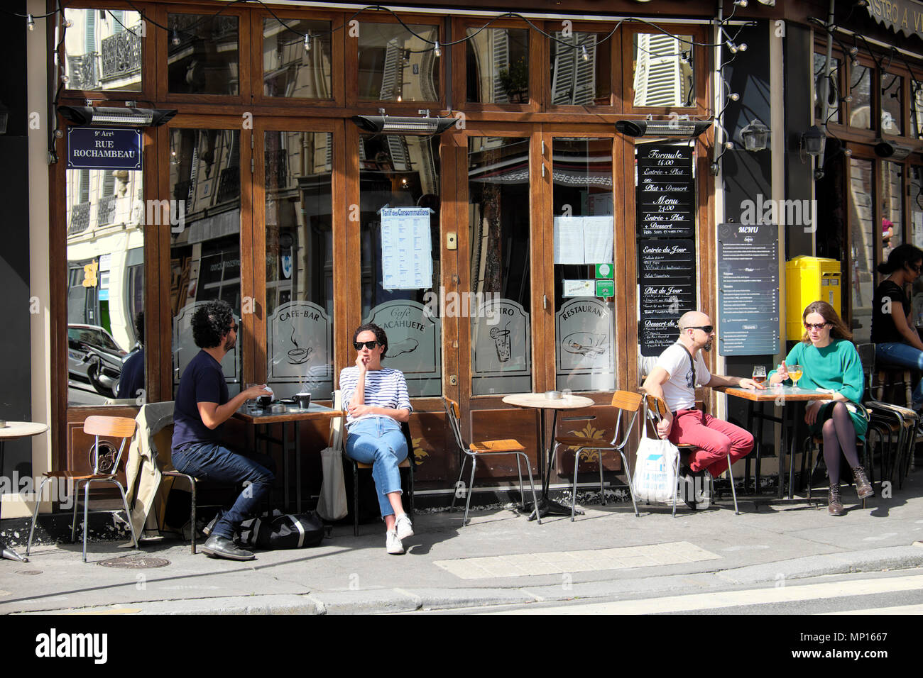People sitting outside Bistro a Vin bar at tables on corner of Rue ...