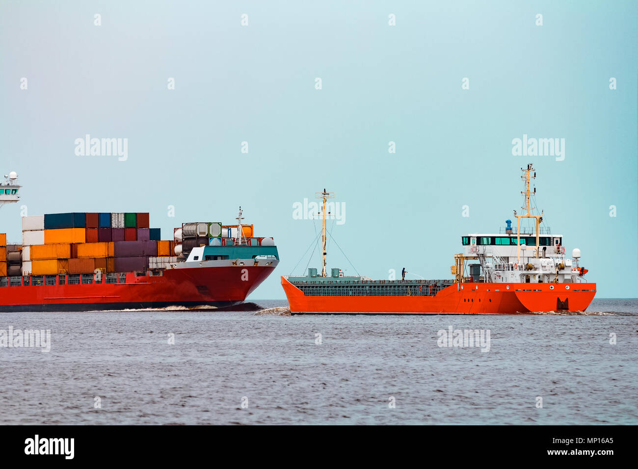 Orange bulker moving past the red container ship in Baltic sea Stock ...