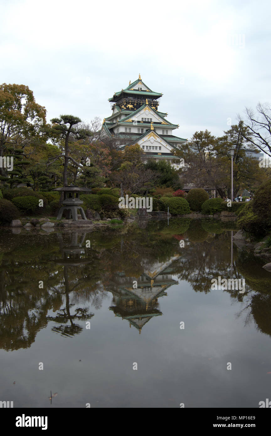 Osaka castle with reflection in pond on a cloudy day, Osaka, Japan ...