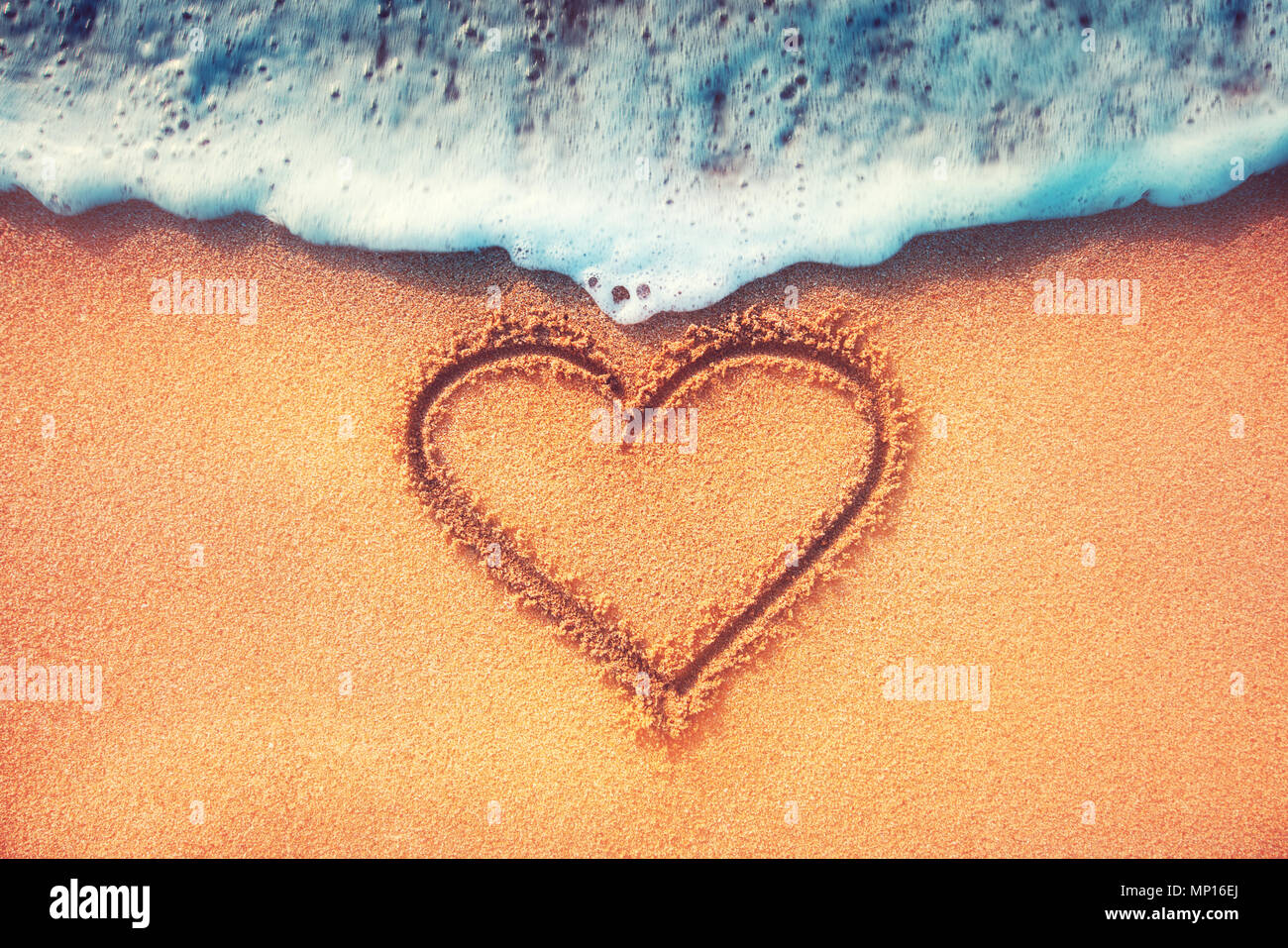 Heart on a sand of beach with wave on background Stock Photo - Alamy