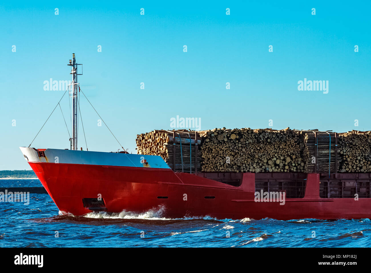 Red cargo ship fully loaded with wood moving at clear day Stock Photo ...