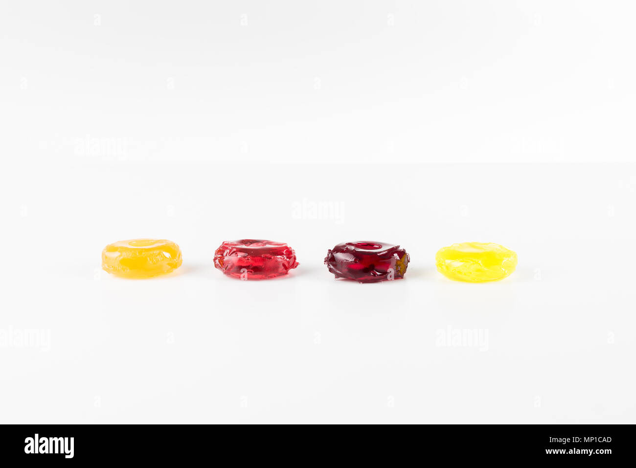 four colourful sweet candies in a row for nibbling Stock Photo - Alamy