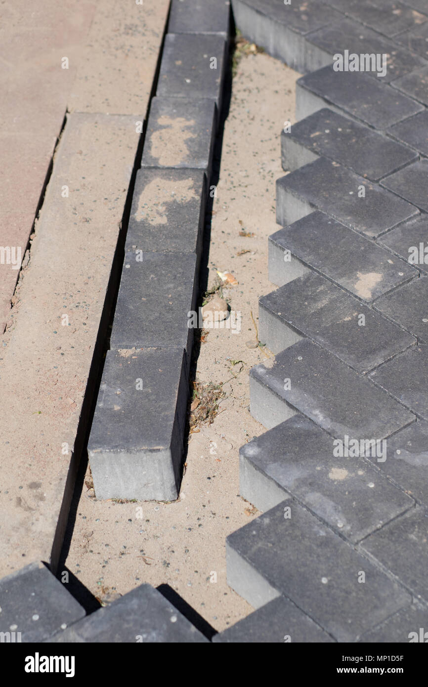 Construction site for a new road for cars. Laying paving blocks, new ...