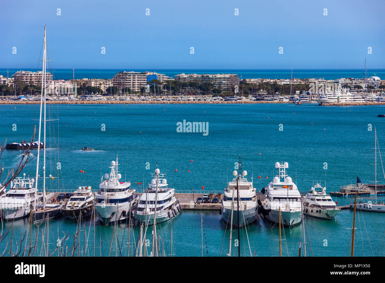 France, Cannes, French Riviera, city skyline and yachts at pier on ...