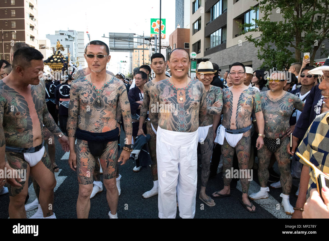 TOKYO, JAPAN - MAY 20: A heavily tattooed Japanese men waits for the mikoshi during Tokyo's one ...