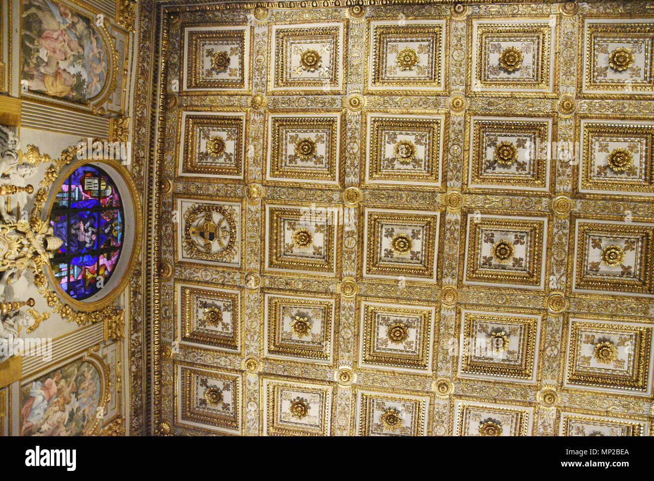 Ornate gold ceiling and stained glass window at Basilica of Santa Maria ...
