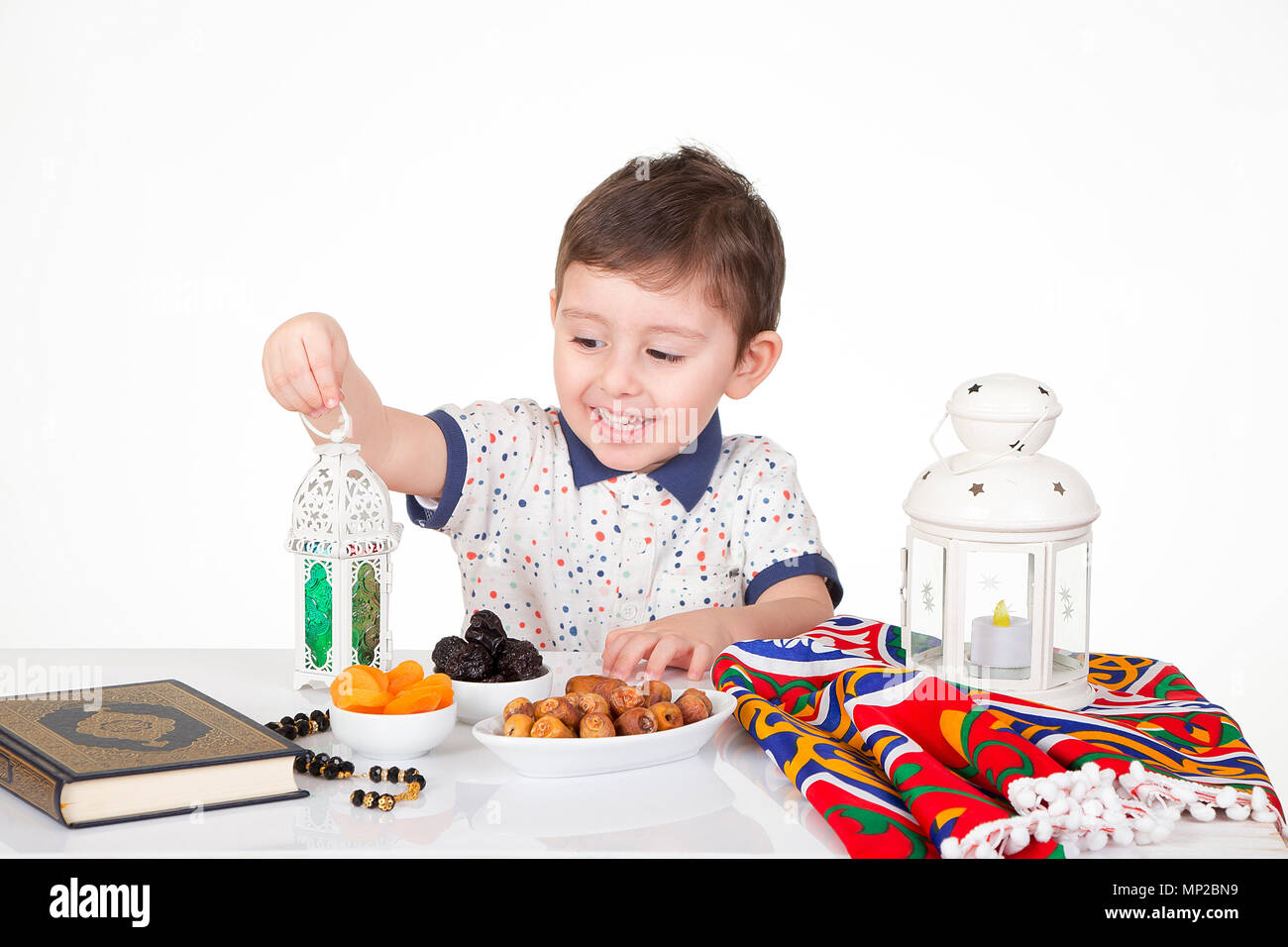 Happy young Muslim boy playing with Ramadan lantern - ready for iftar ...