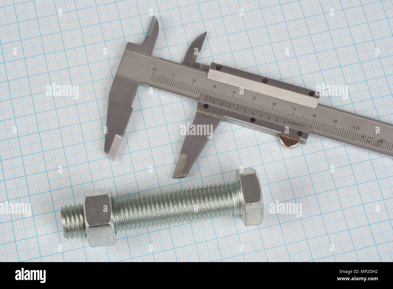 Screw, Nuts and caliper on graph paper background Stock Photo - Alamy
