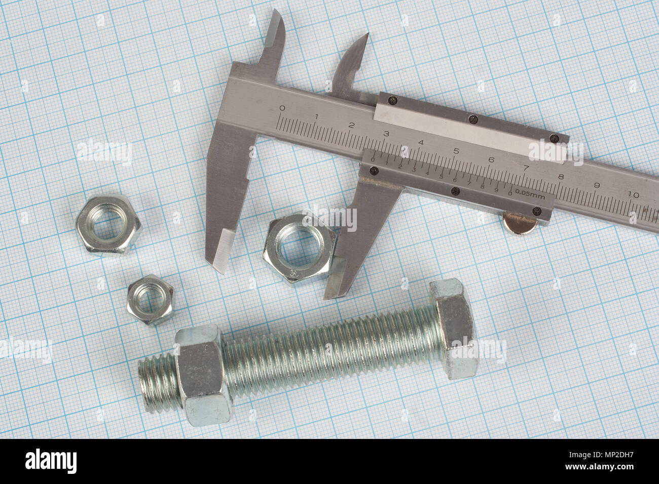 Screw, Nuts and caliper on graph paper background Stock Photo - Alamy