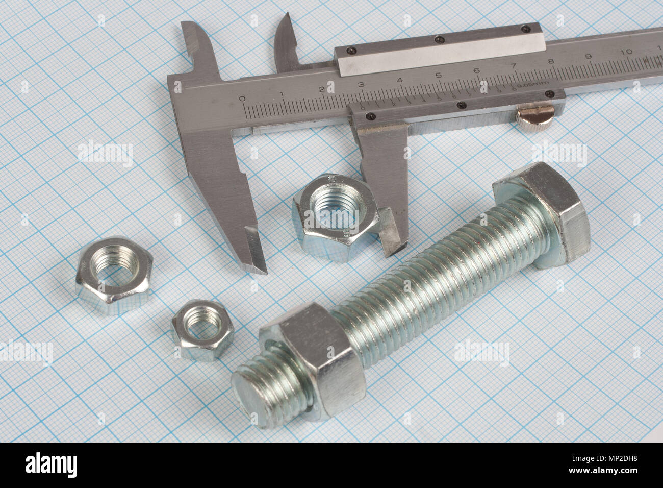 Screw, Nuts and caliper on graph paper background Stock Photo - Alamy