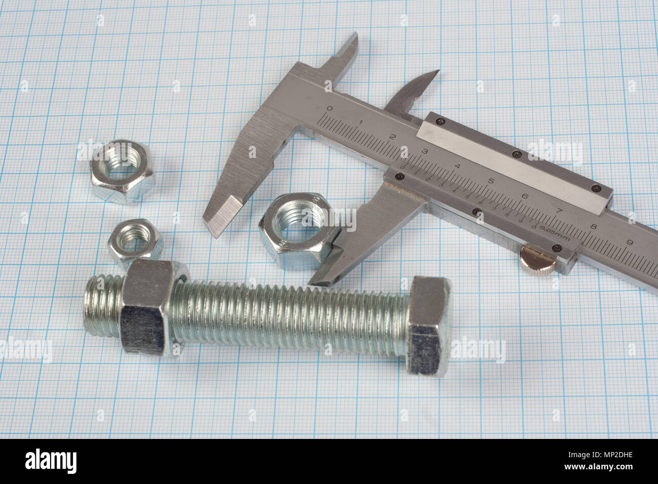 Screw, Nuts and caliper on graph paper background Stock Photo - Alamy