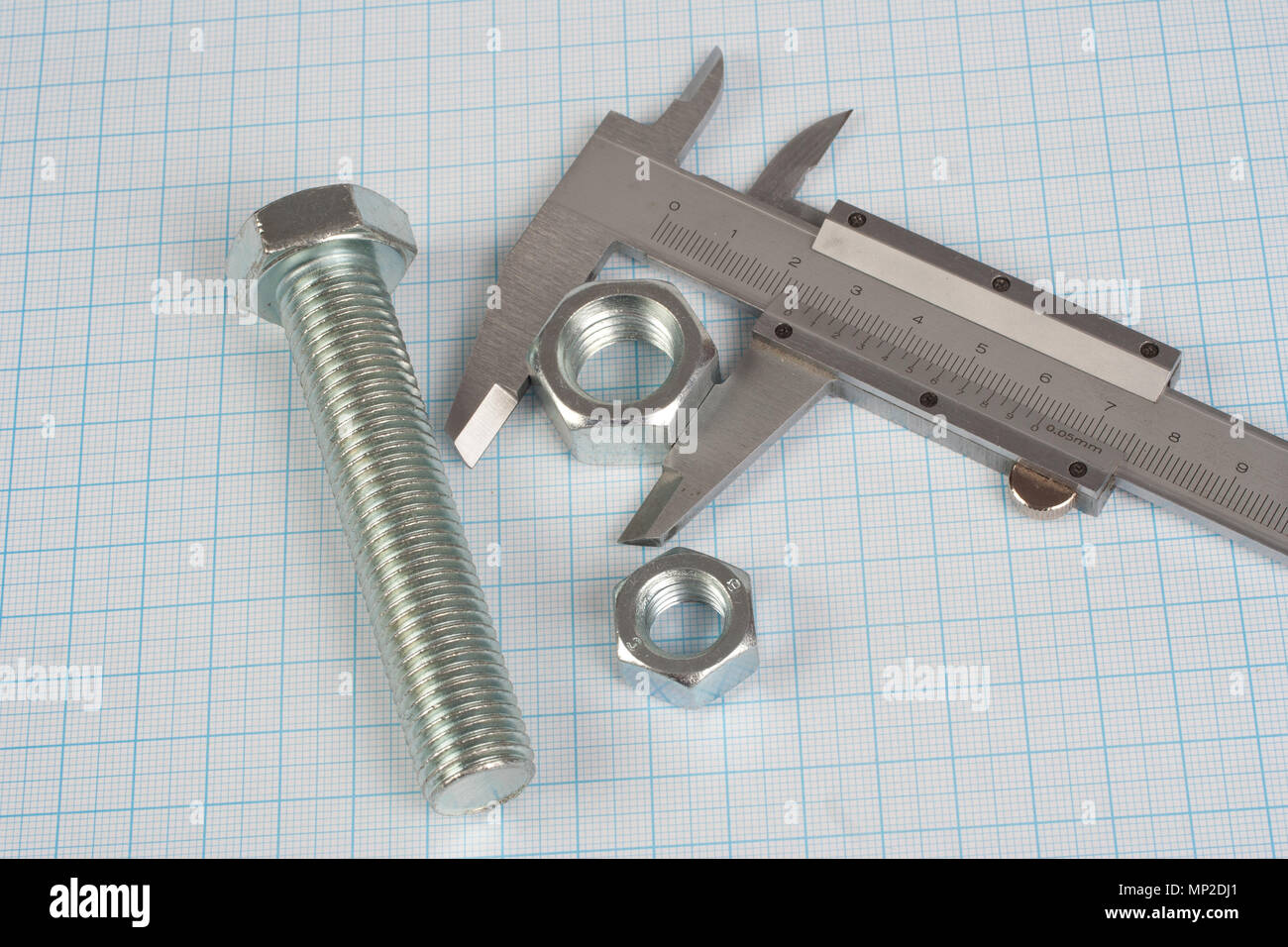 Screw, Nuts and caliper on graph paper background Stock Photo - Alamy