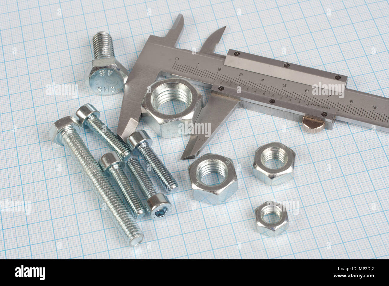 Screw, Nuts and caliper on graph paper background Stock Photo - Alamy