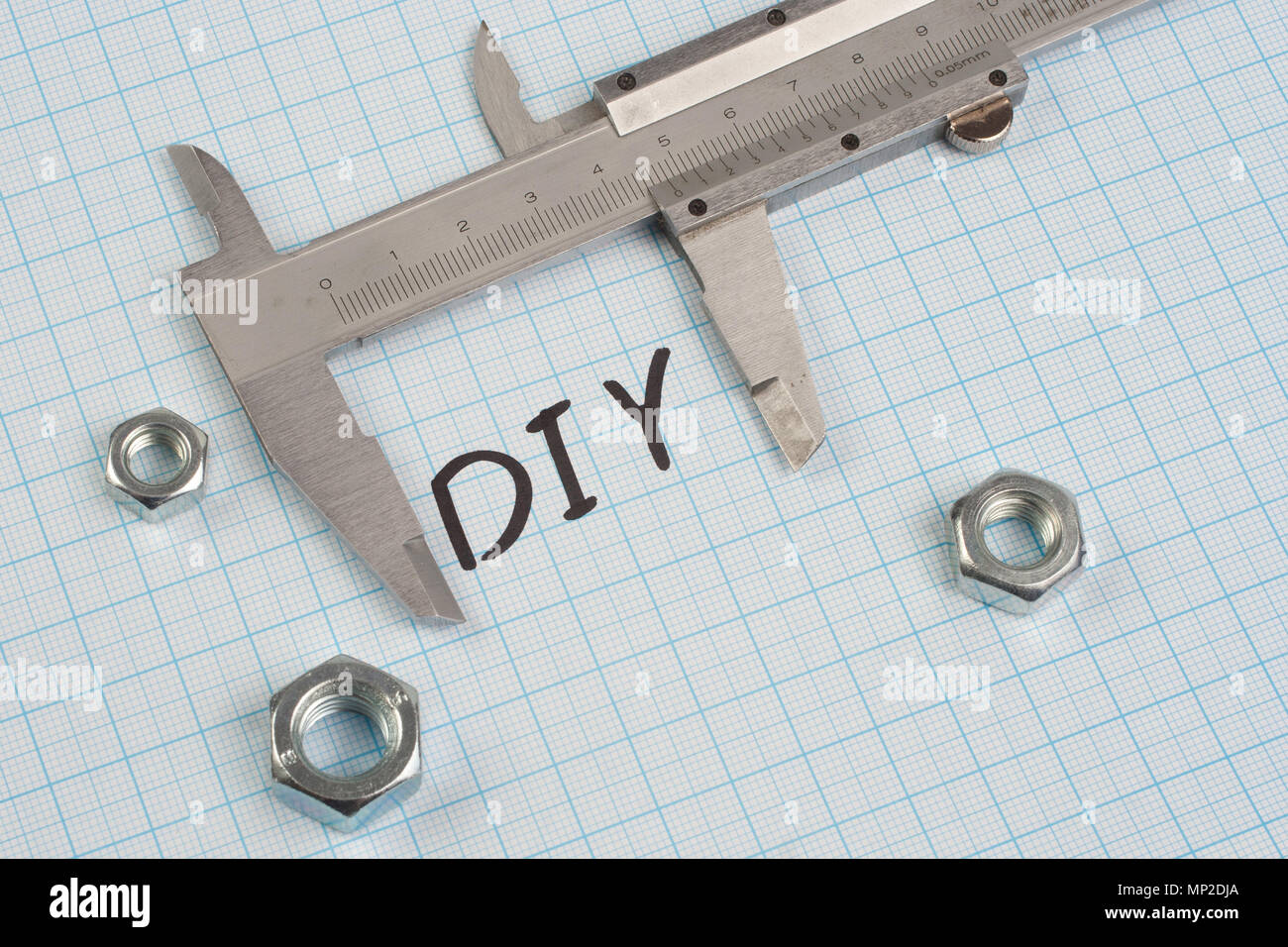 "Do it yourself" - Screw, Nuts and caliper on graph paper background ...