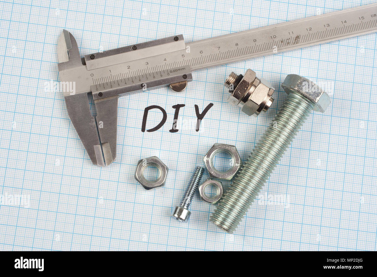 "Do it yourself" - Screw, Nuts and caliper on graph paper background ...