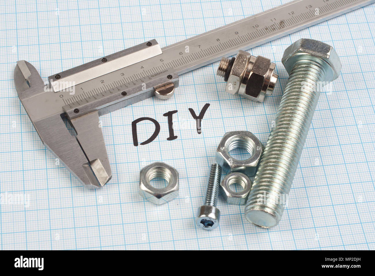 "Do it yourself" - Screw, Nuts and caliper on graph paper background ...