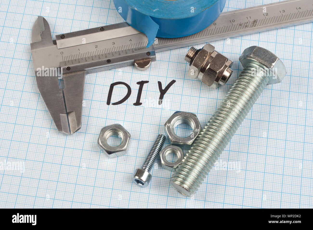 "Do it yourself" - Screw, Nuts and caliper on graph paper background ...