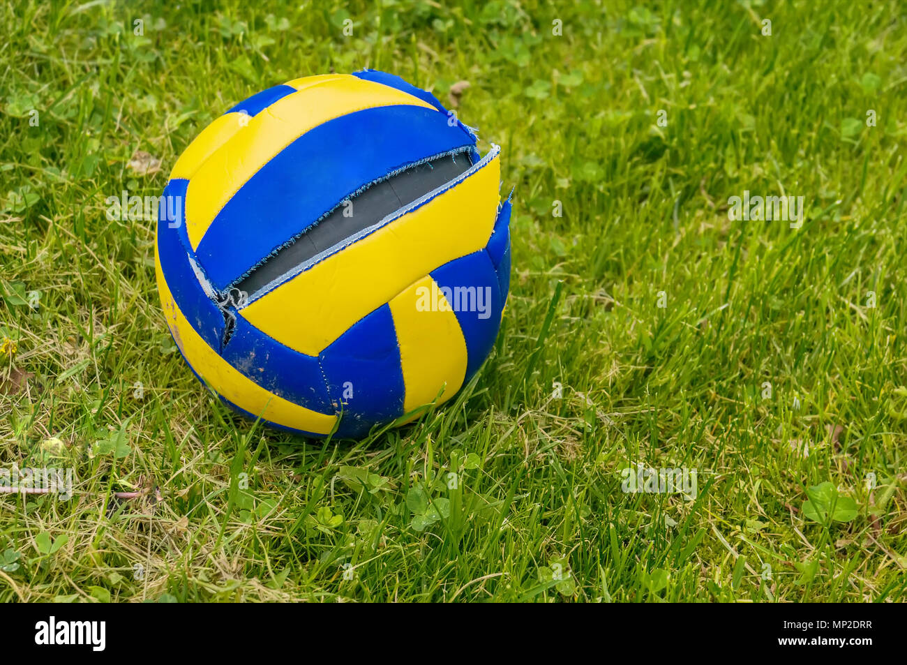 Dirty old ripped soccer ball on the grass after the game. Competitions ...