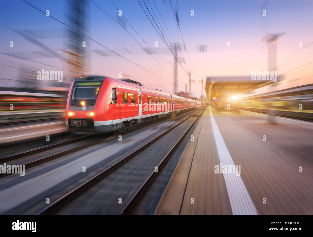 High speed red train with motion blur effect on the railway station at ...