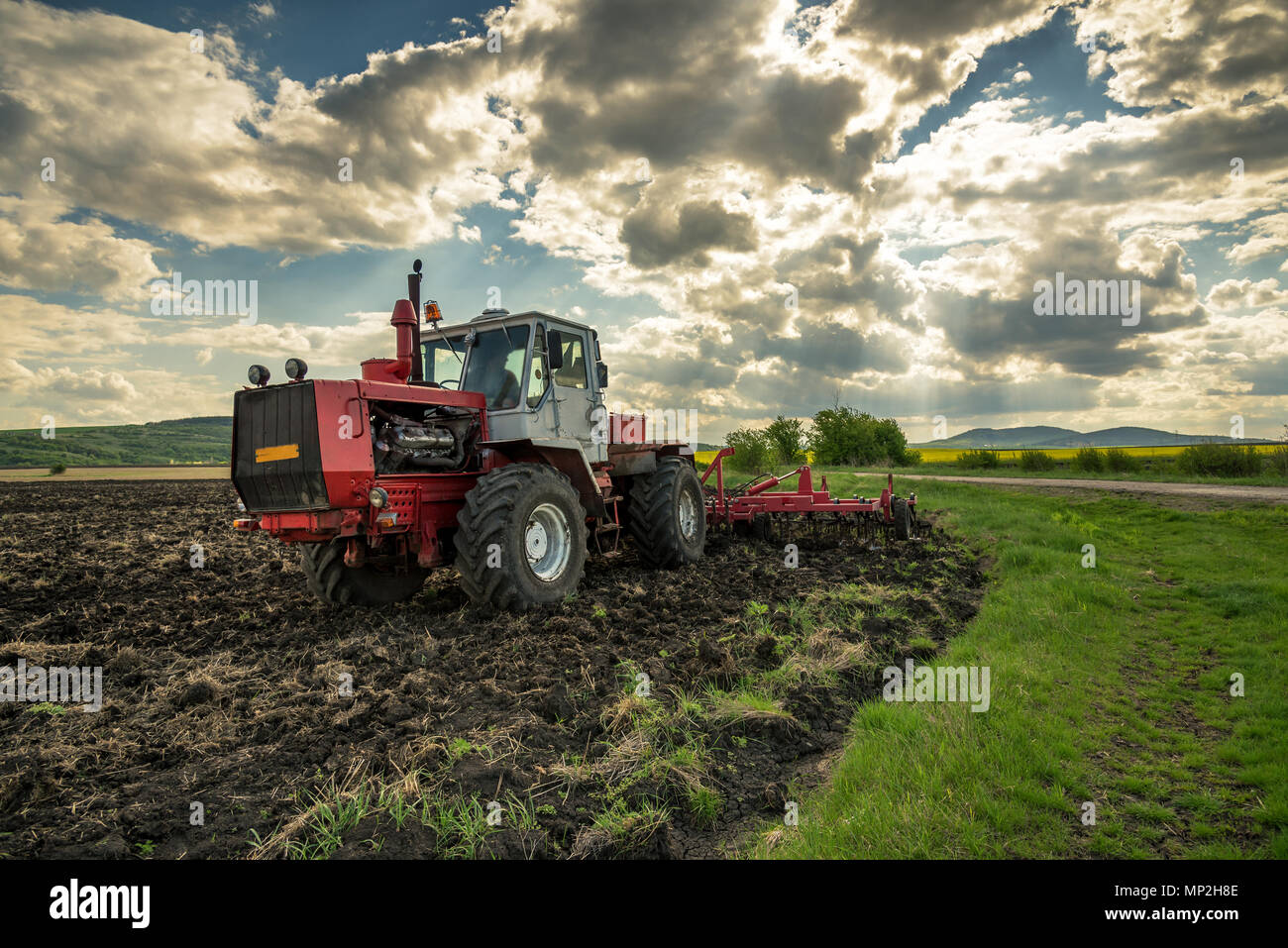 Farmer in tractor preparing land with seedbed cultivator Stock Photo ...