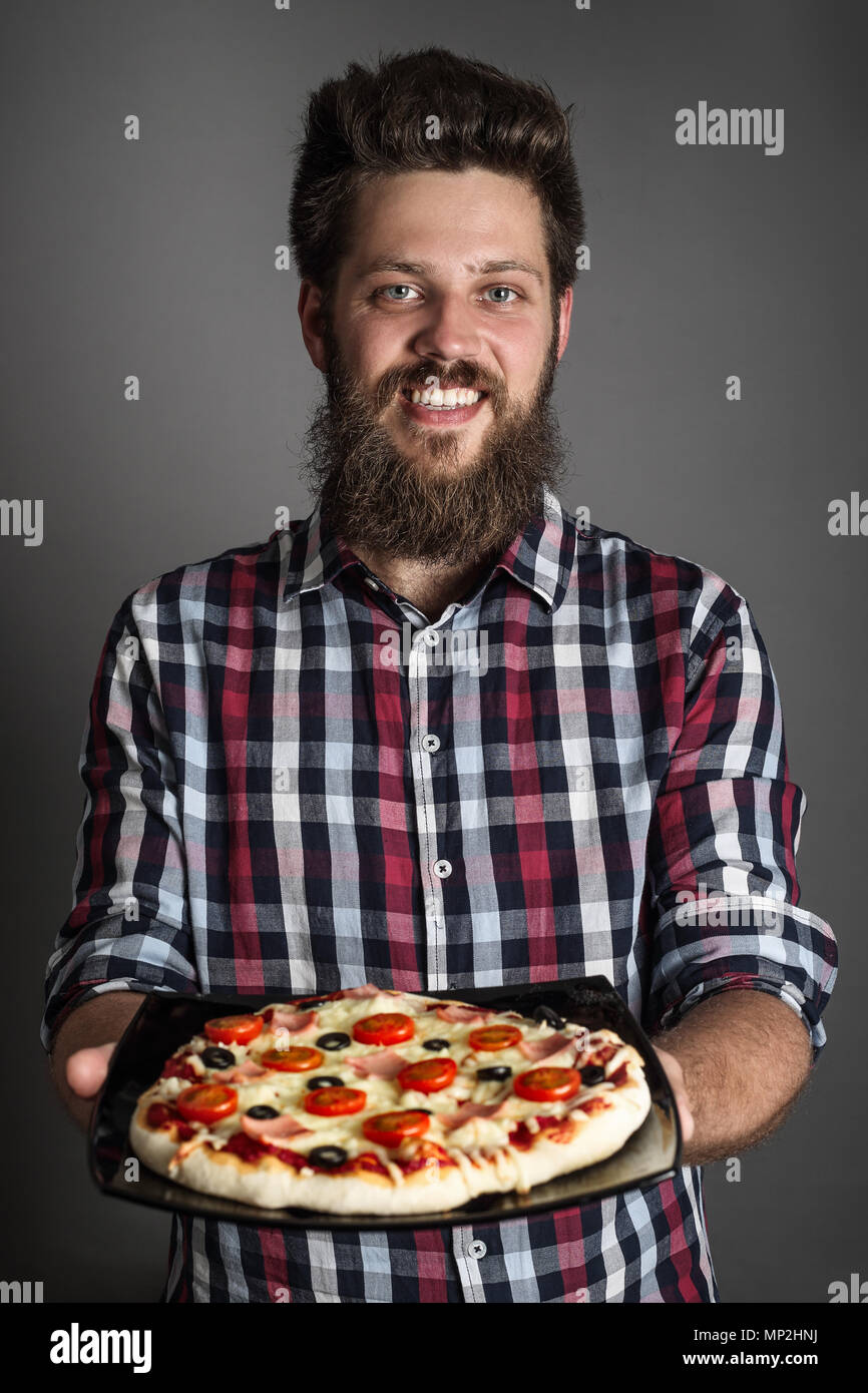 Happy smiling man holding home made pizza Stock Photo - Alamy