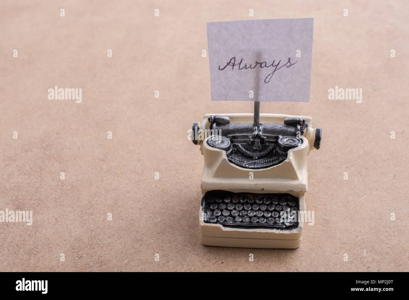 Retro syled tiny typewriter model on a brown background Stock Photo - Alamy