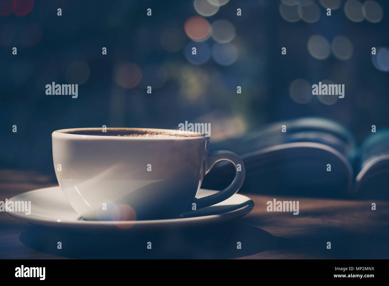 cup of coffee with magazine on table in cafe in dark tone and vintage ...