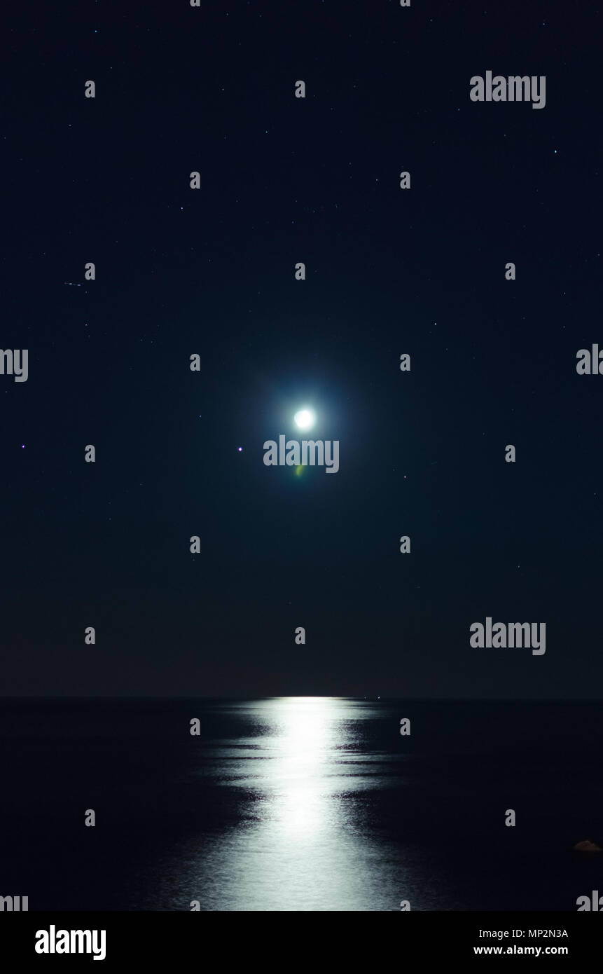 Full moon over dark water with reflections on it. The moonlight on the ...