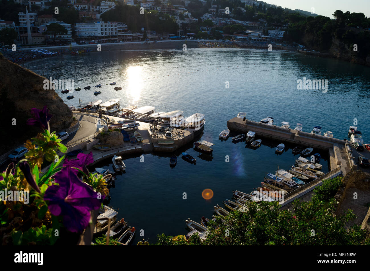 Small fishing boats marina with round pier. Wide angle shot with a city ...
