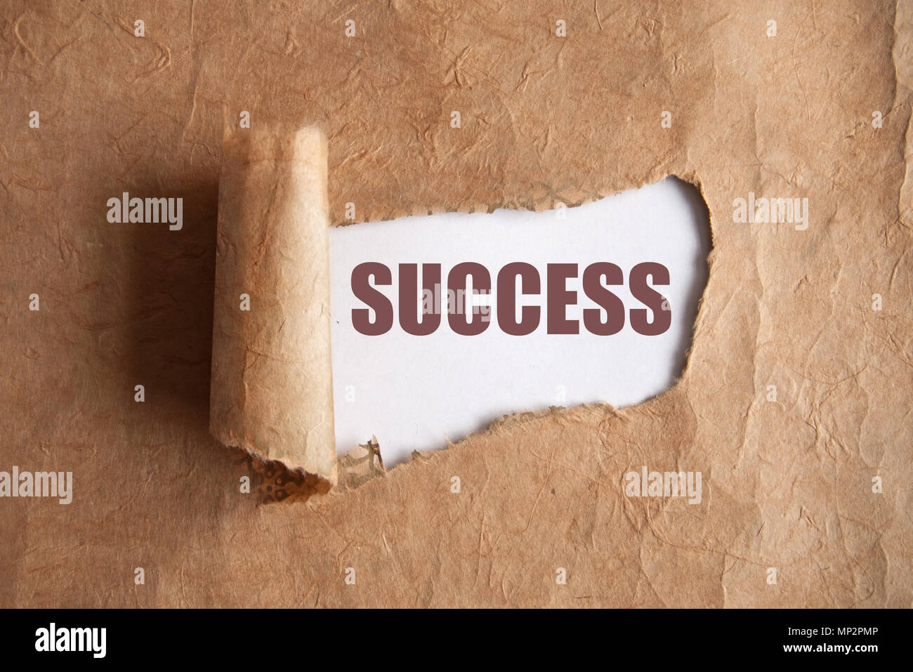 Torn piece of scroll uncovering success Stock Photo - Alamy