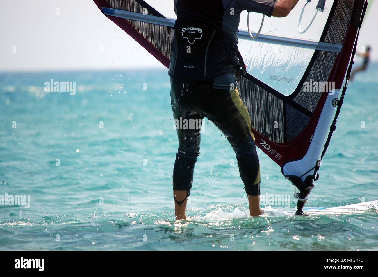 The surfer is standing on his board and getting ready to compete ...