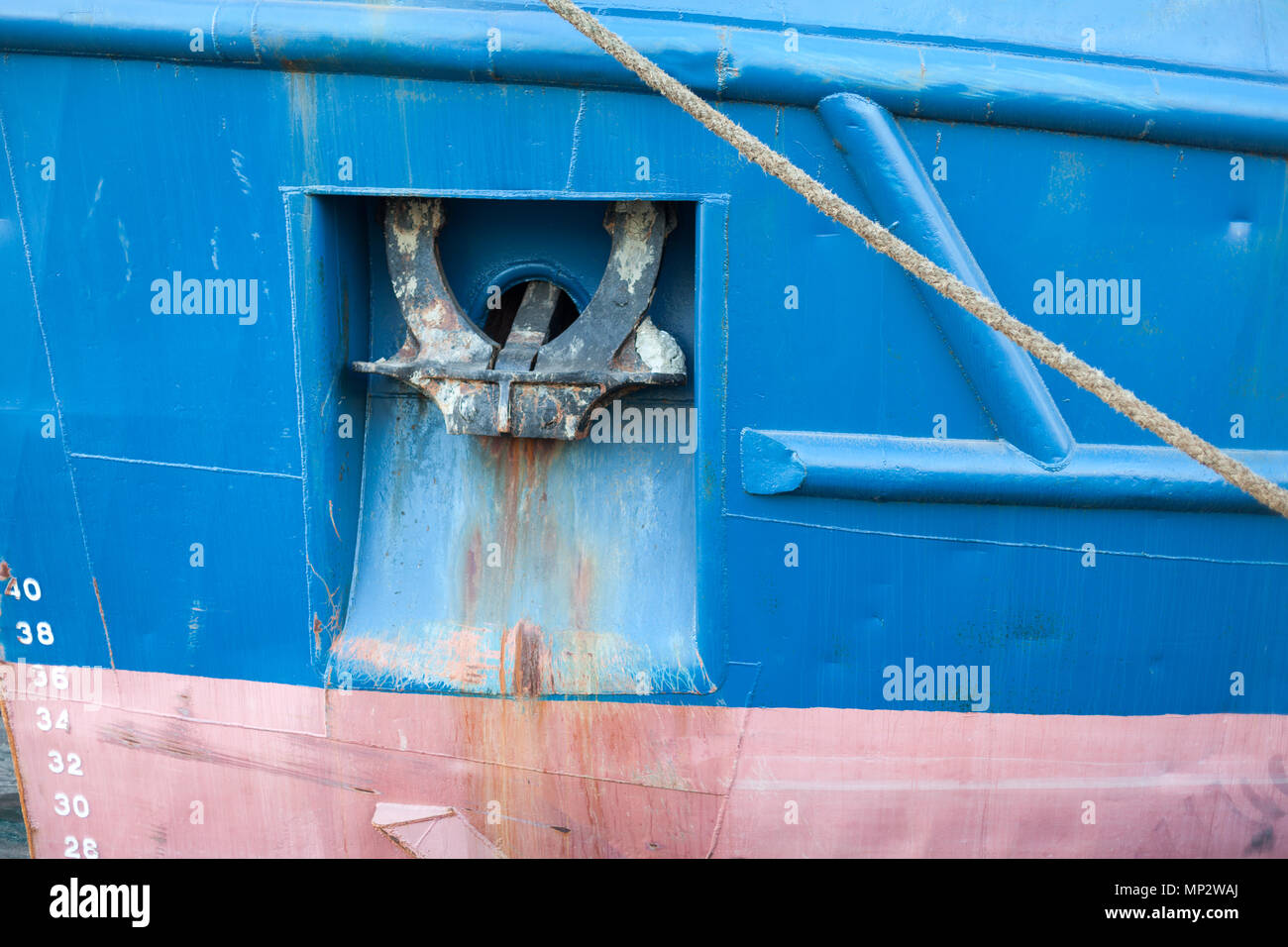 low angle view of the bow of a red shipping tanker anchored in port ...