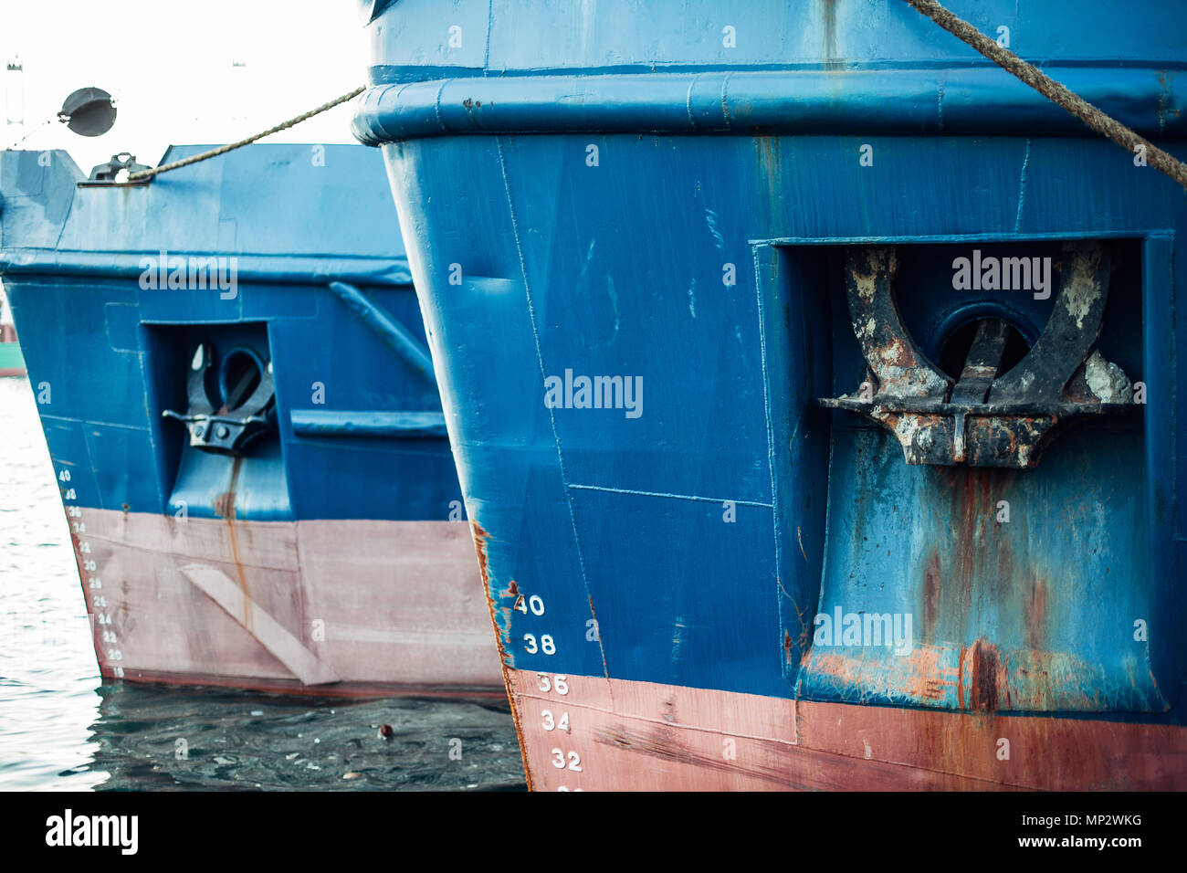 low angle view of the bow of a red shipping tanker anchored in port ...