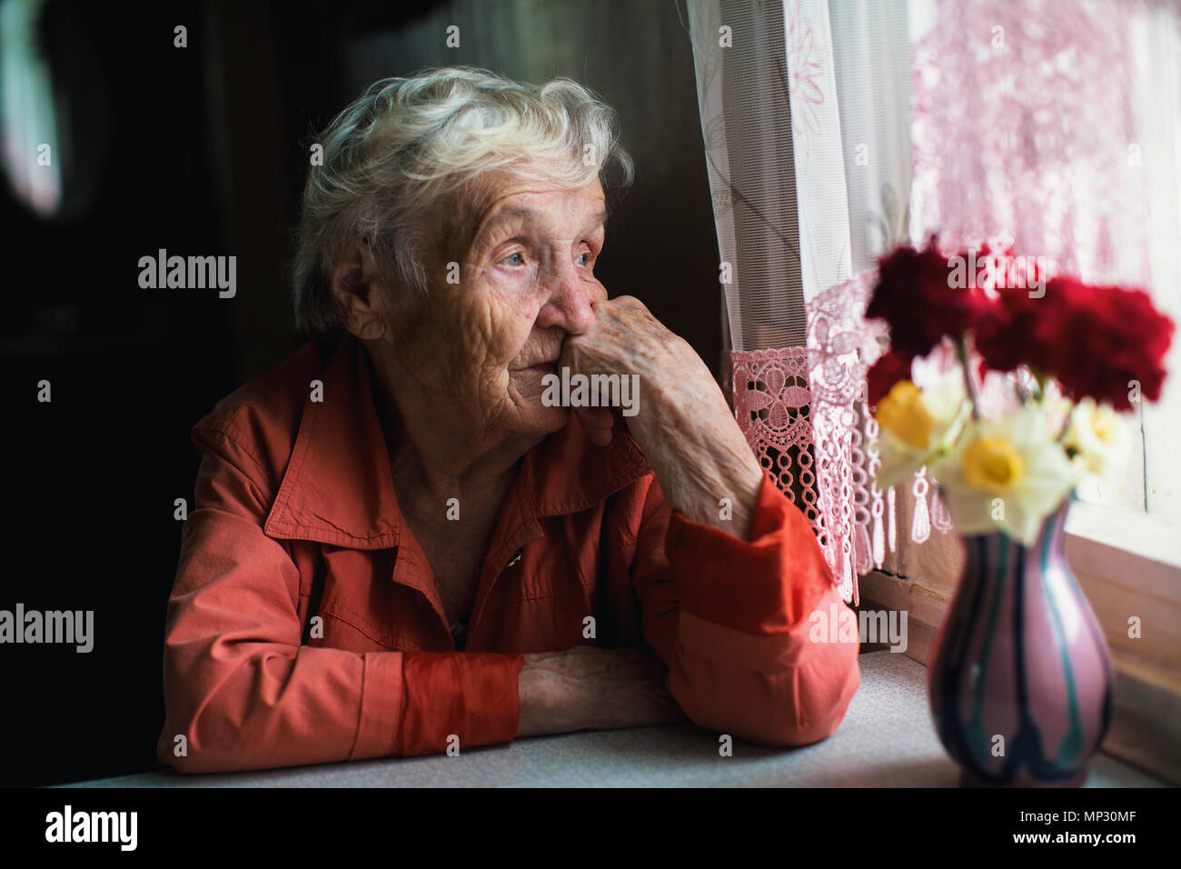 Elderly woman looks sadly out the window Stock Photo - Alamy Elderly woman looks sadly out the window Stock Photo - Alamy