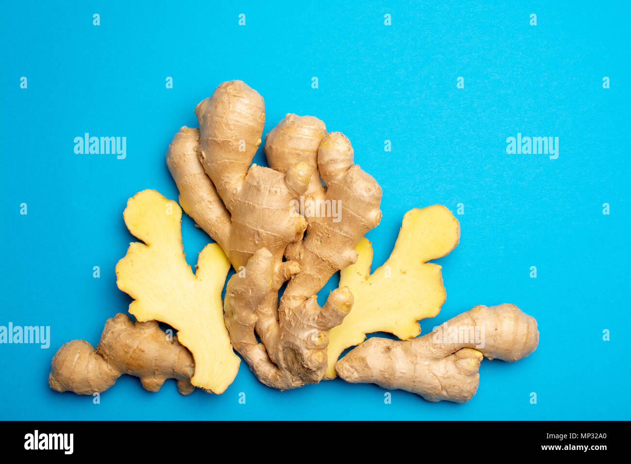 Trendy food flat lay concept on blue background with fresh big ginger ...