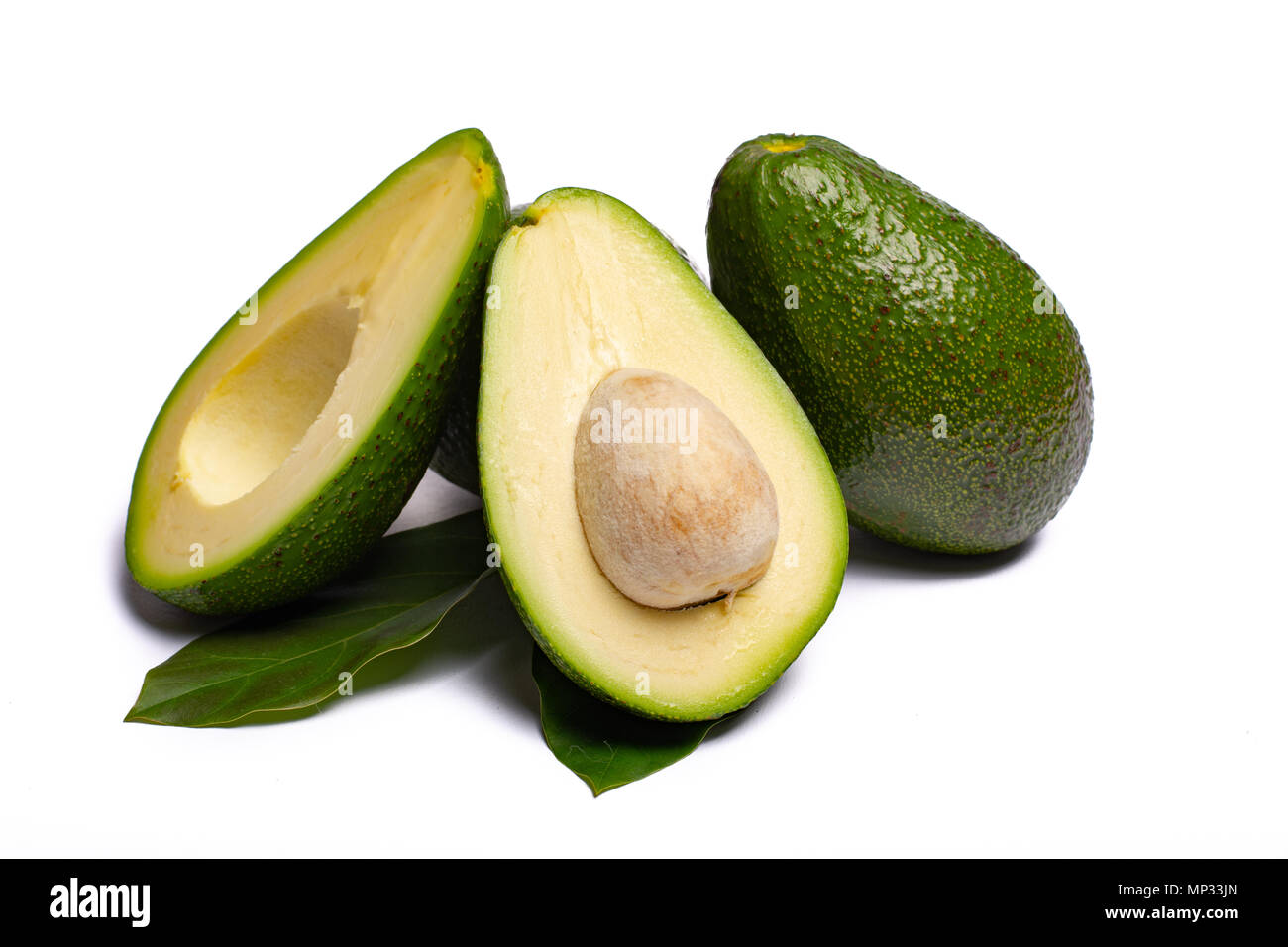 Fresh organic ripe green whole and sliced Fuerte avocado with leaves ...