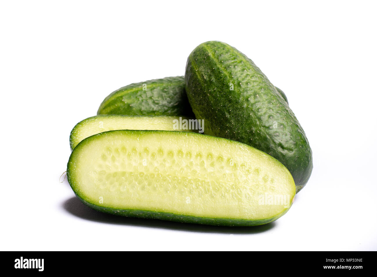Fresh small green cucumbers whole and sliced close up copy space ...